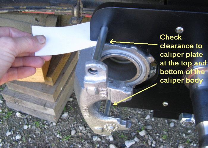 Test the fit the caliper against the support arms of the caliper plate ...